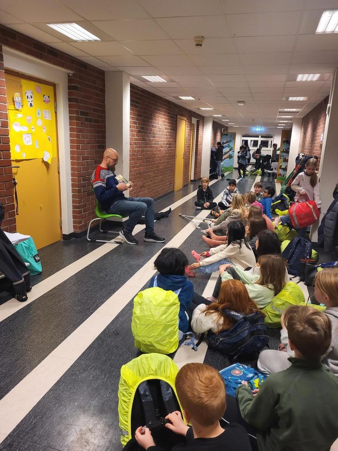 Trones skole - Rektor leser på gangen for 4 trinn.